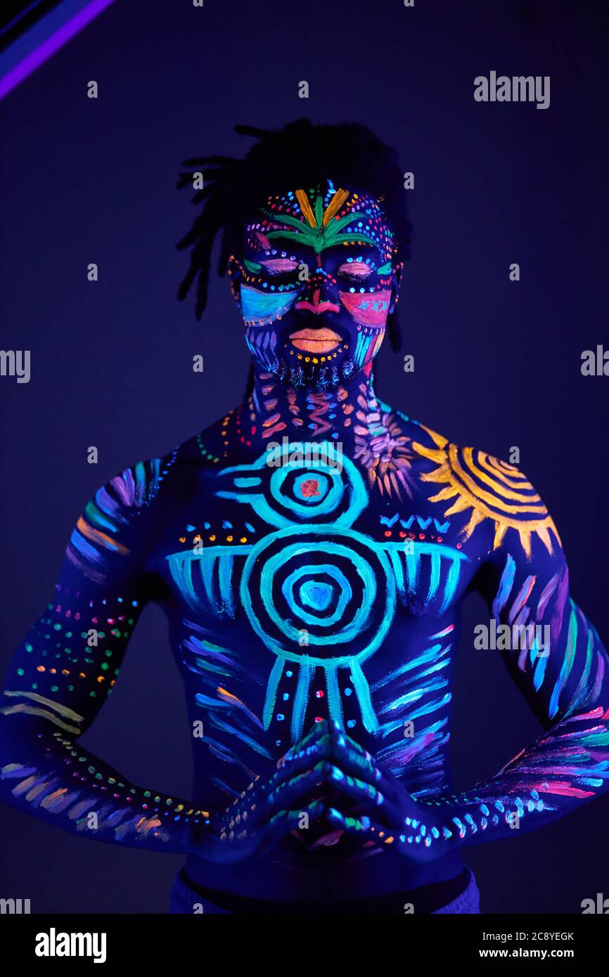 colorful fluorescent body art with ethnic prints, young male posing at ...
