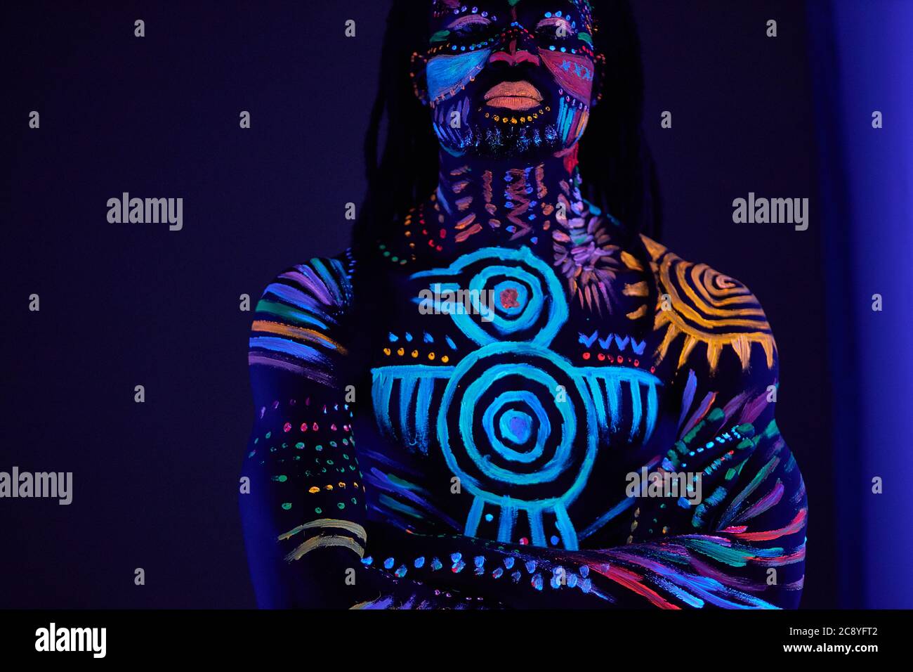 portrait of strong muscular male covered with fluorescent luminescence ...