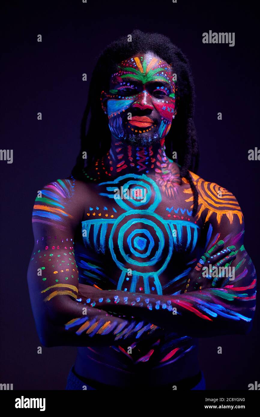 portrait of african man painted in fluorescent paint on face and ...