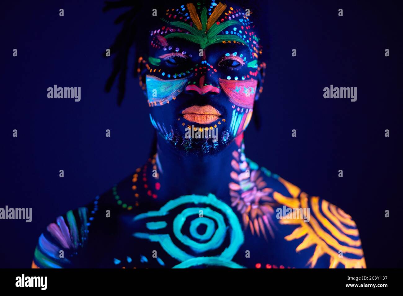 colorful fluorescent body art with ethnic prints, young male posing at ...