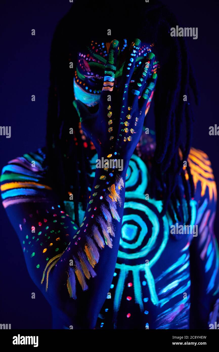 handsome african guy with UV body art close his face, colorful ...