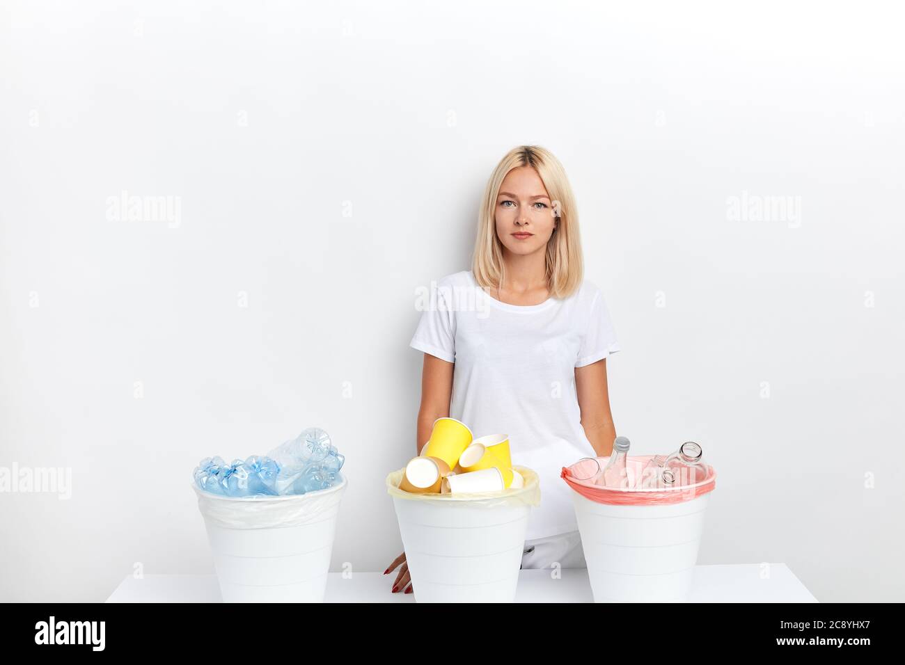 Waste management, Woman staanding behind three recycle bins. Waste ...