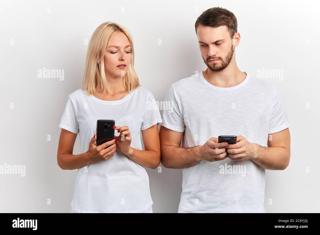 two attractive people comparing their smart phones, close up portrait ...