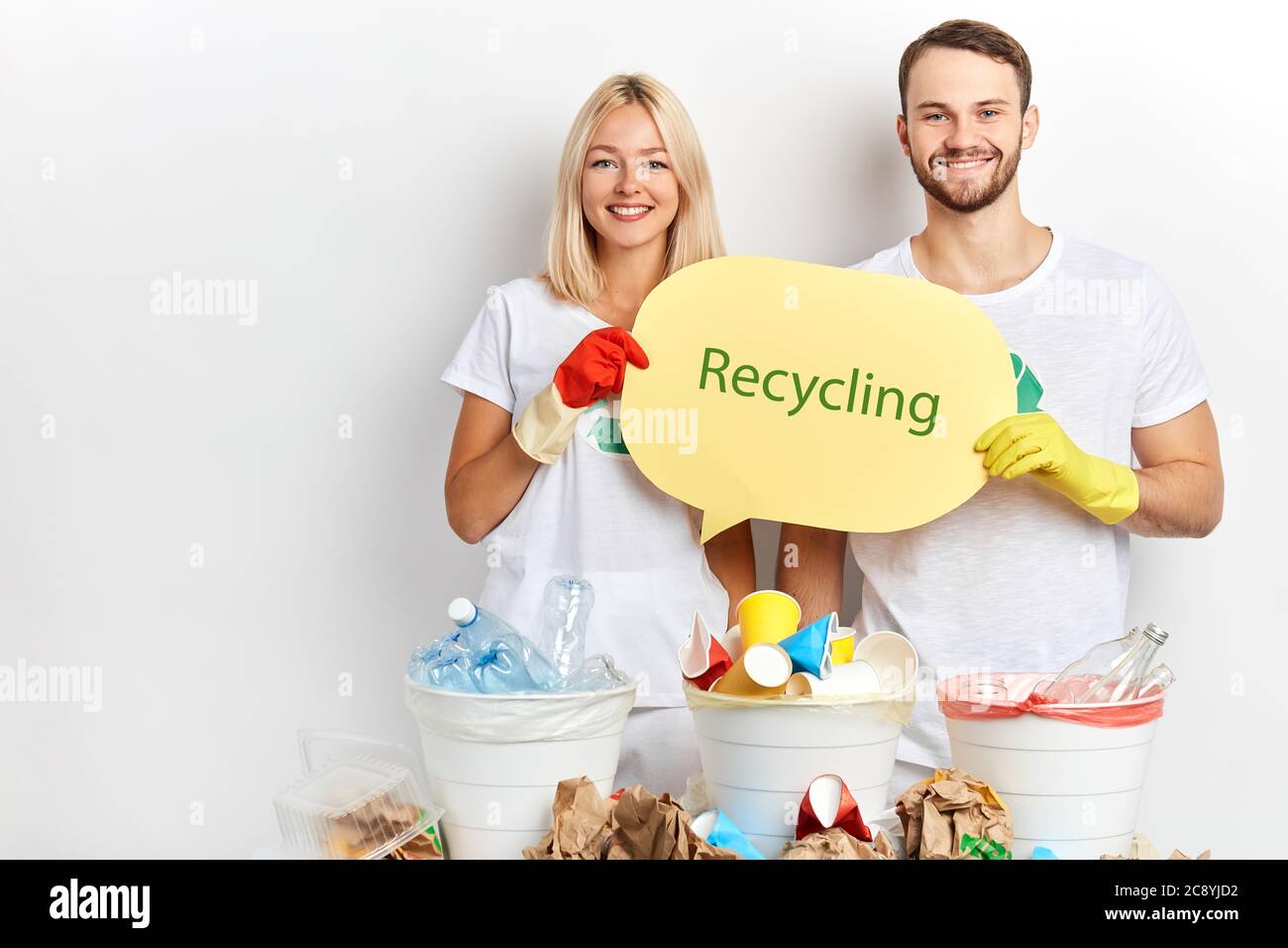 positive smiling young man and woman advising people to recycle waste ...