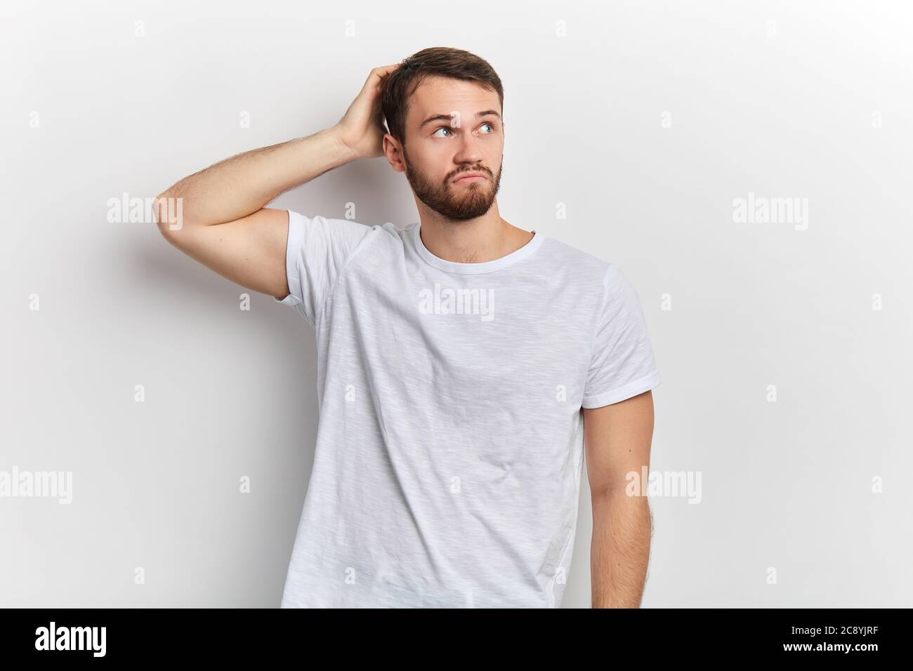 serious man scratching head, thinking deeply about problem trying to ...