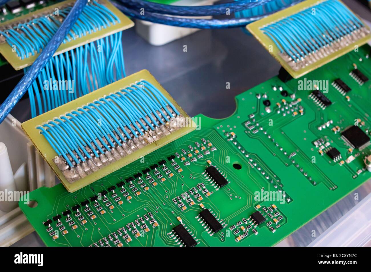 Green PCB and blue wires close up, macro photo Stock Photo - Alamy