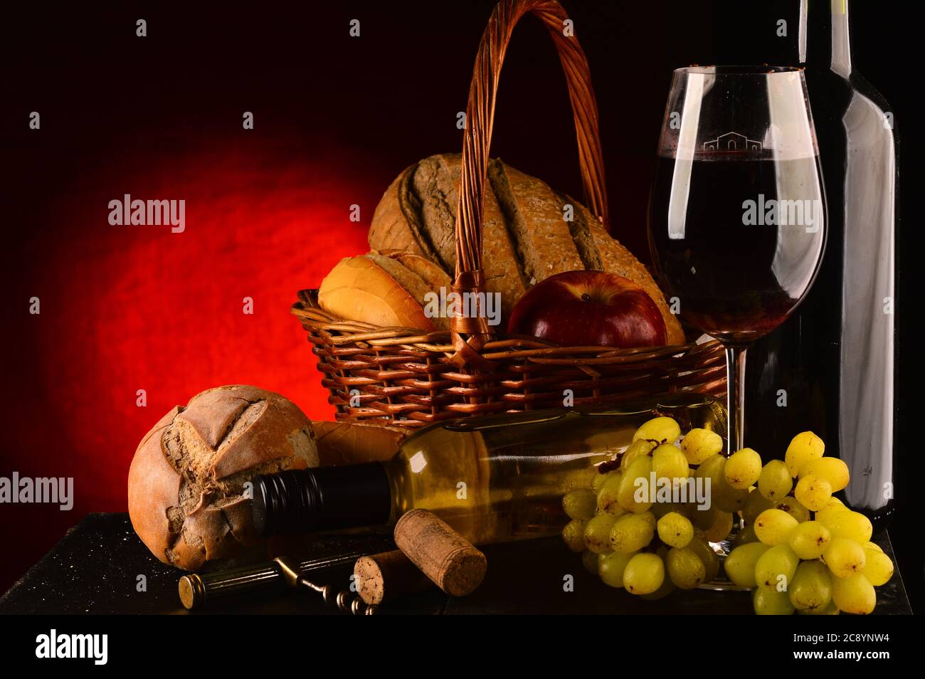 Glass of red wine and the bottle nearby, bread and barrel studio shot ...