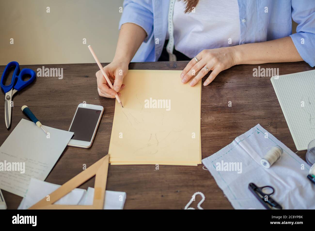 Unrecognizable woman drawing sketch on blank craft paper sheet sitting ...