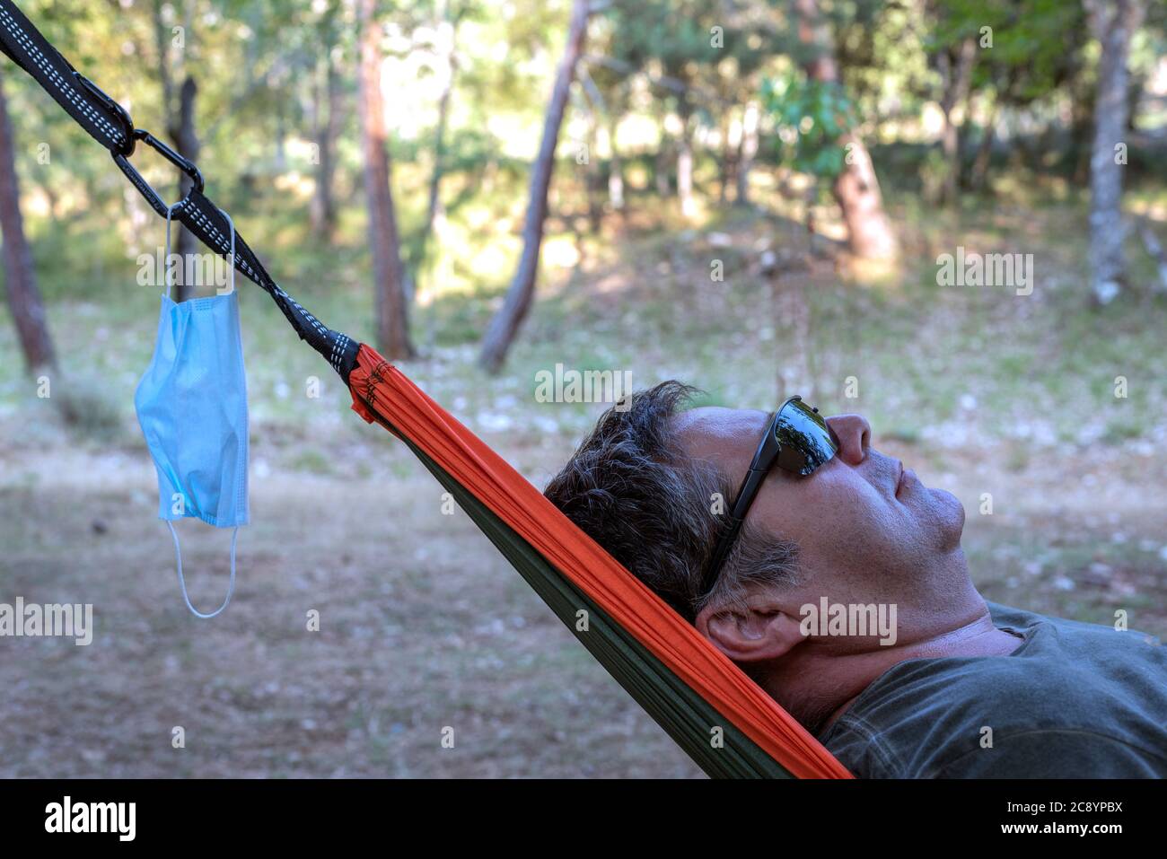 Man resting outside with mask off Stock Photo - Alamy