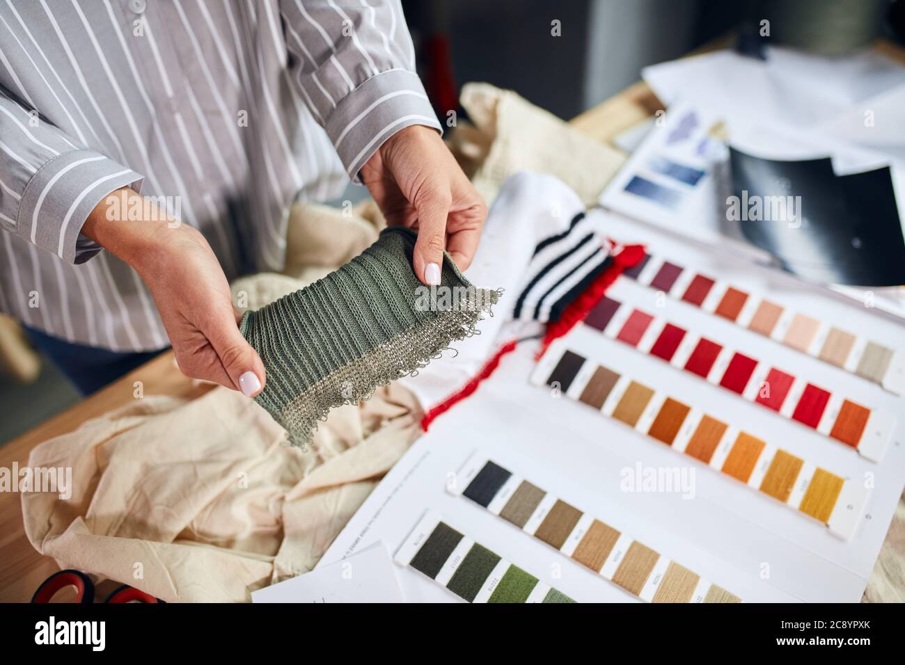 female fashion designer choosing colors for new collection discussing ...