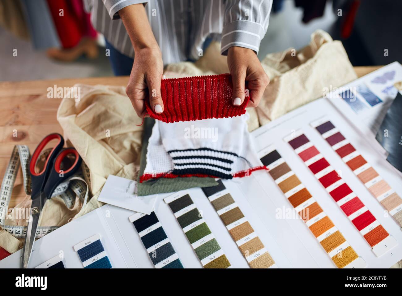 dressmaker making decision what color of textile to use to make clothes ...