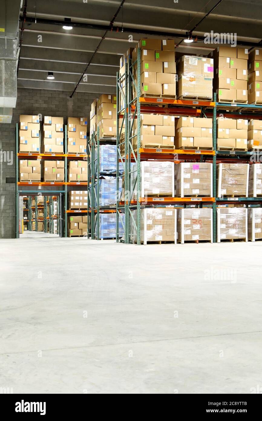 Boxes of merchandise on wood pallettes sitting on shelves in a ...
