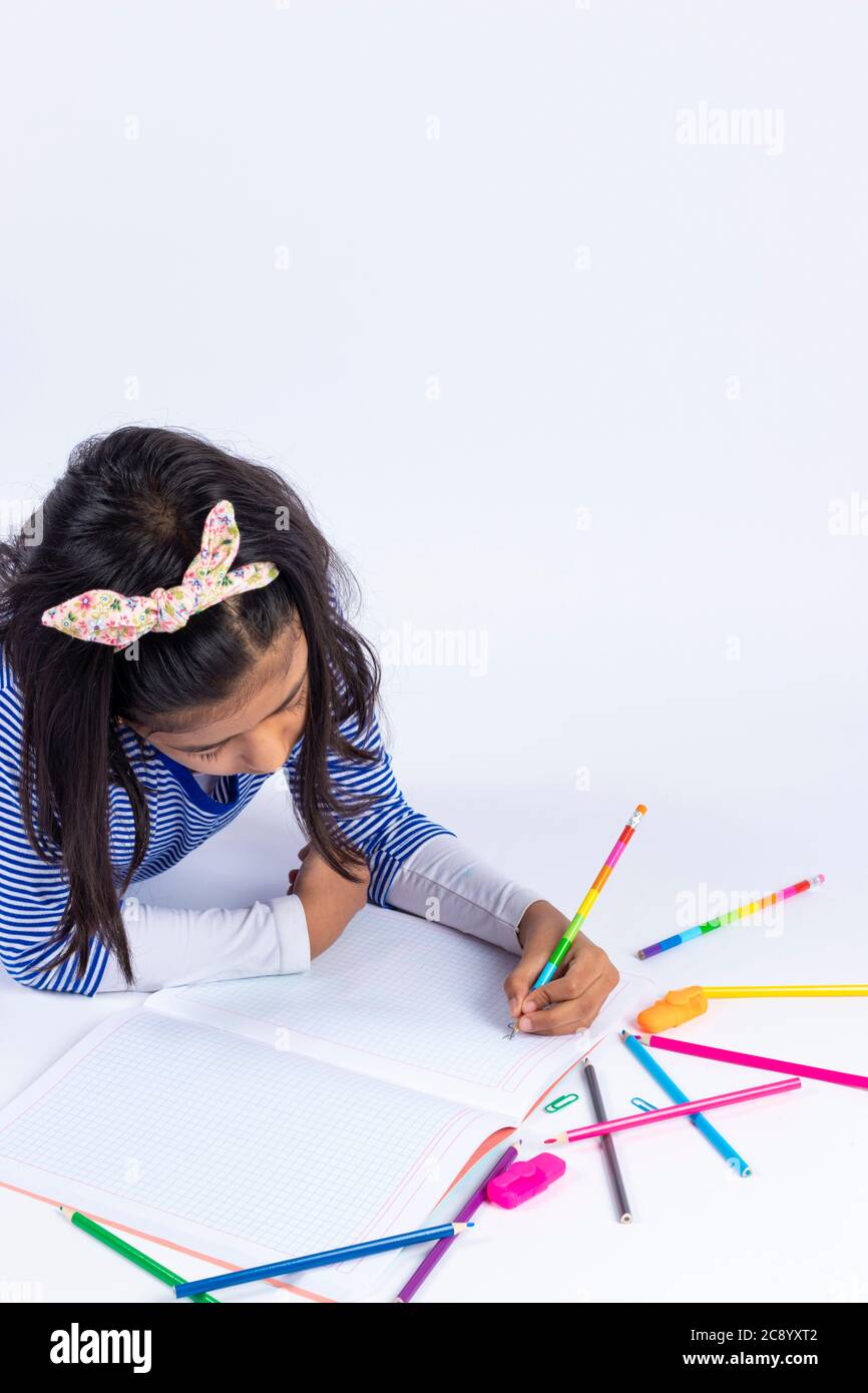 Cute left-handed girl is writing with a pencil in her notebook Stock ...