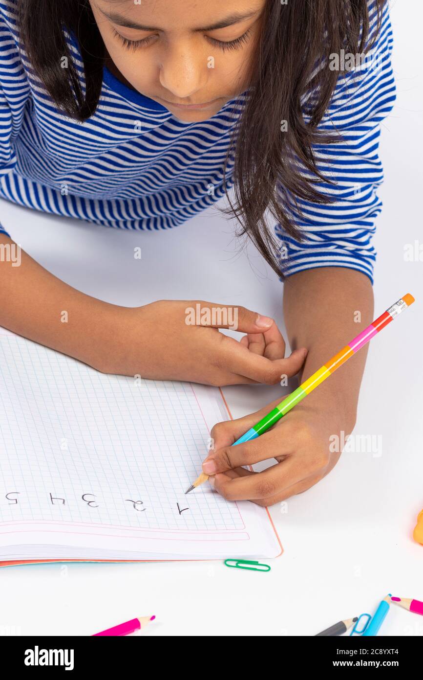 Cute left-handed girl is writing with a pencil in her notebook Stock ...