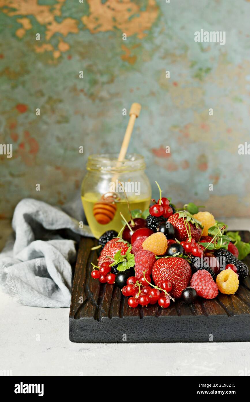 Summer berries on a wooden board close-up. Berry fruits like ...