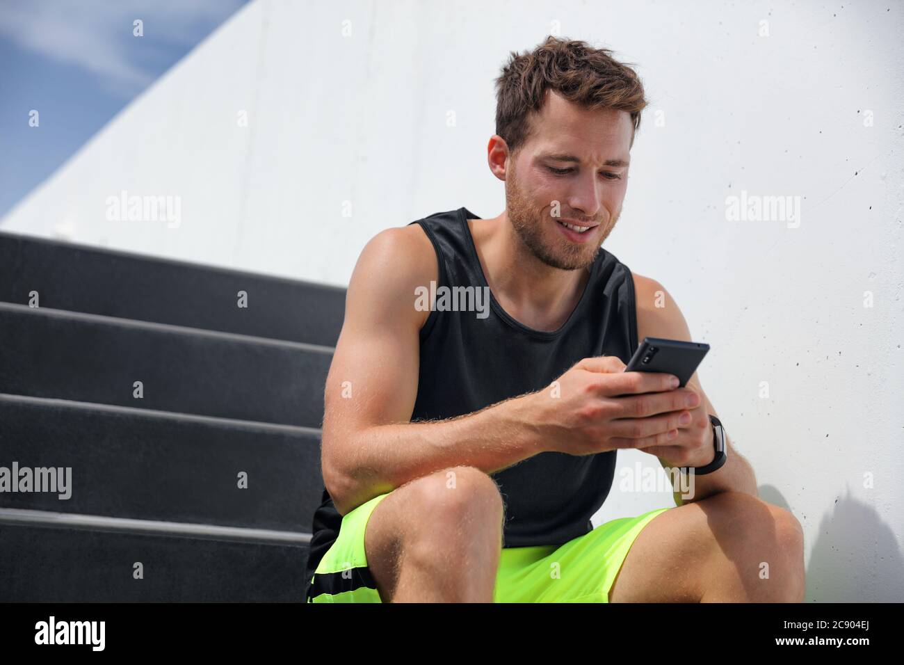 Fitness man runner using smart phone texting sms wearing smartwatch for ...