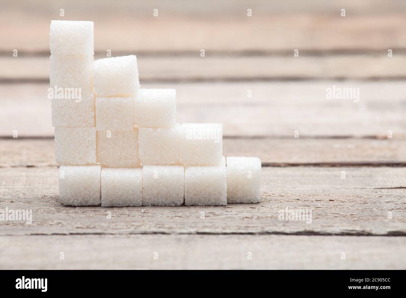The refined sugar put by a pyramid on a wooden table from old boards ...