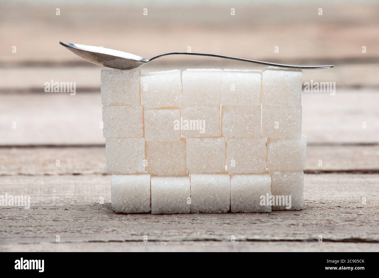 The refined sugar put by a pyramid on a wooden table from old boards ...