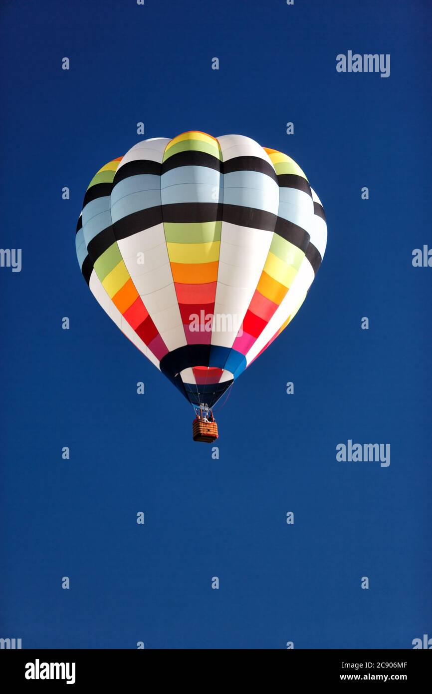 An aerial view of a colorful hot air balloon against a blue sky ...