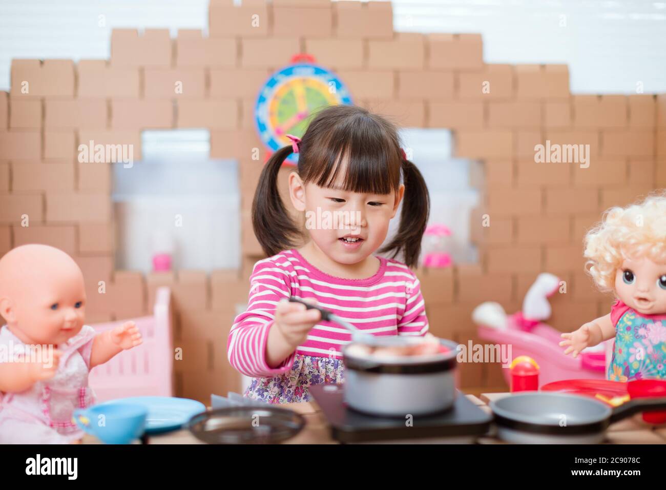 young girl pretend play babysitting with baby doll at home Stock Photo ...