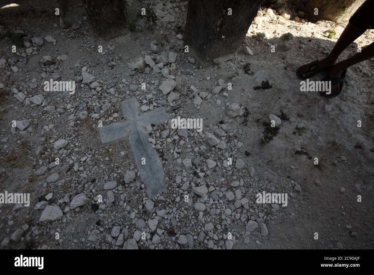 A villager showing the details of a Christian grave which is located ...