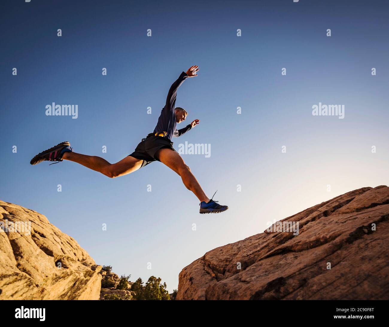 USA, Utah, St. George, Man jumping over rocks while running in ...