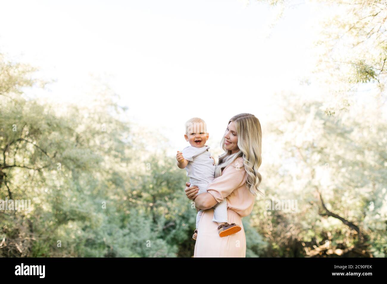 Mother carrying baby boy in nature Stock Photo - Alamy