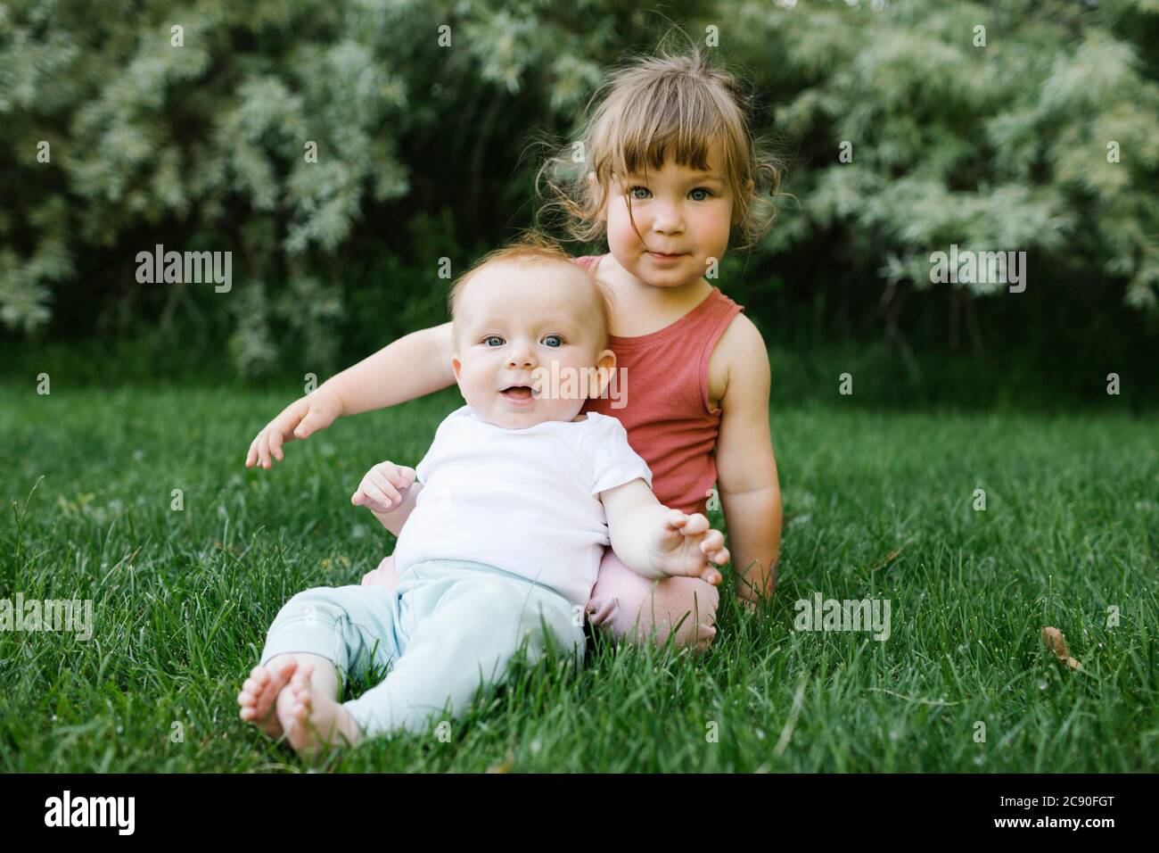 Outdoor portrait of kids sitting in grass Stock Photo - Alamy