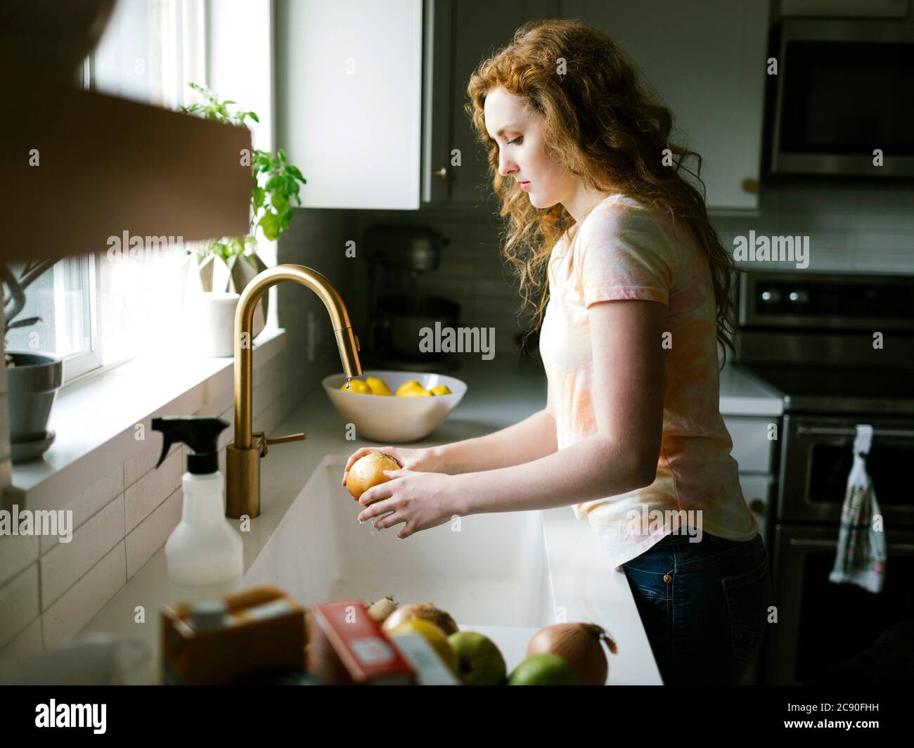 Woman washing onion Stock Photo - Alamy