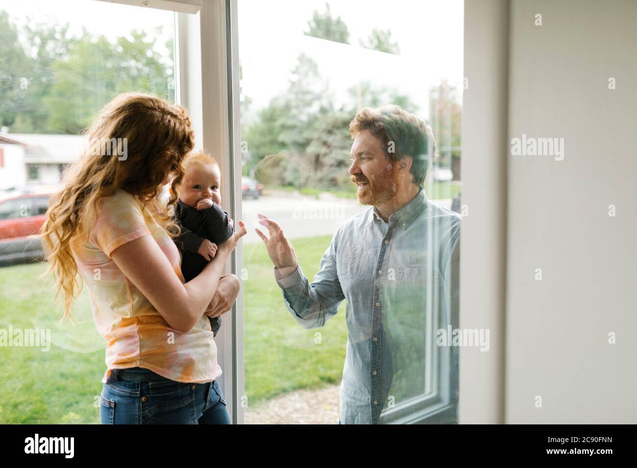 Father visiting partner and son (6-11 months) through window Stock ...