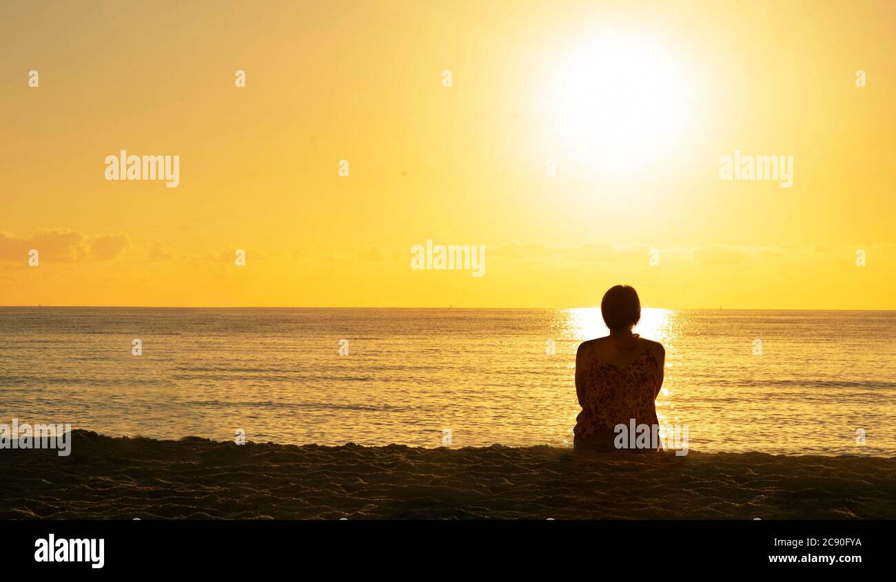 Woman sitting on beach sunset hi-res stock photography and images - Alamy