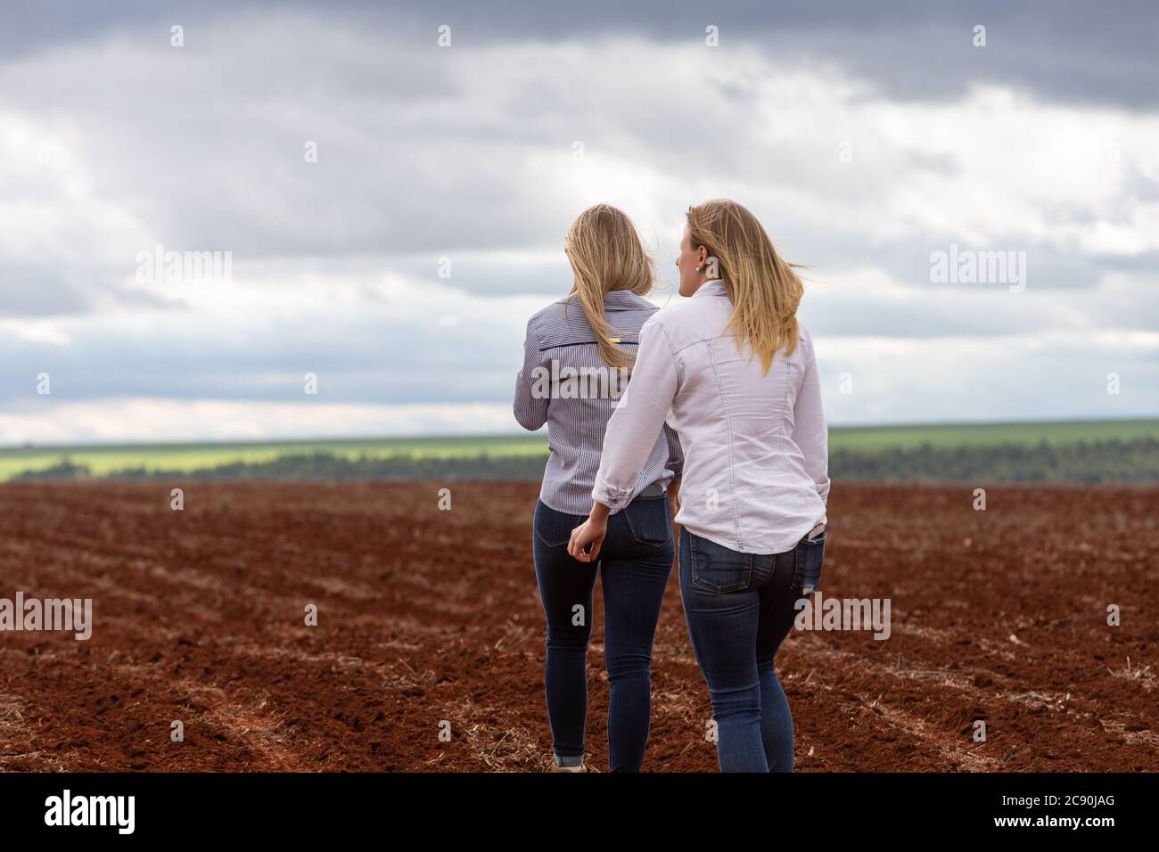 two females country farmer girls sisters walking on field rural scene ...