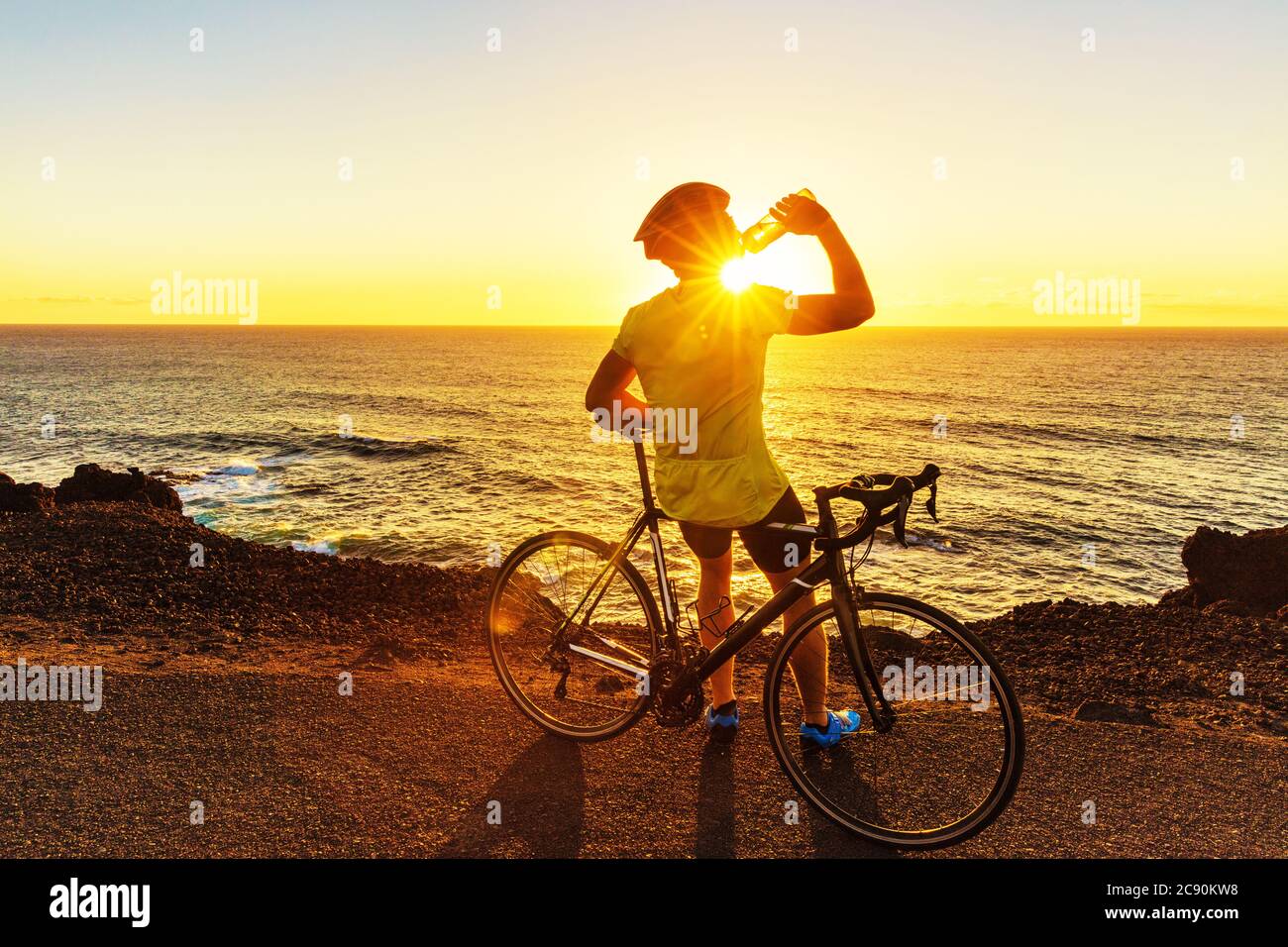 Athlete cyclist man drinking water on bike Stock Photo - Alamy