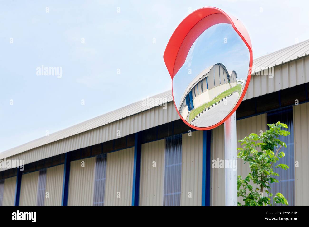 Mirror view with the exterior of a warehouse building with a blue sky ...