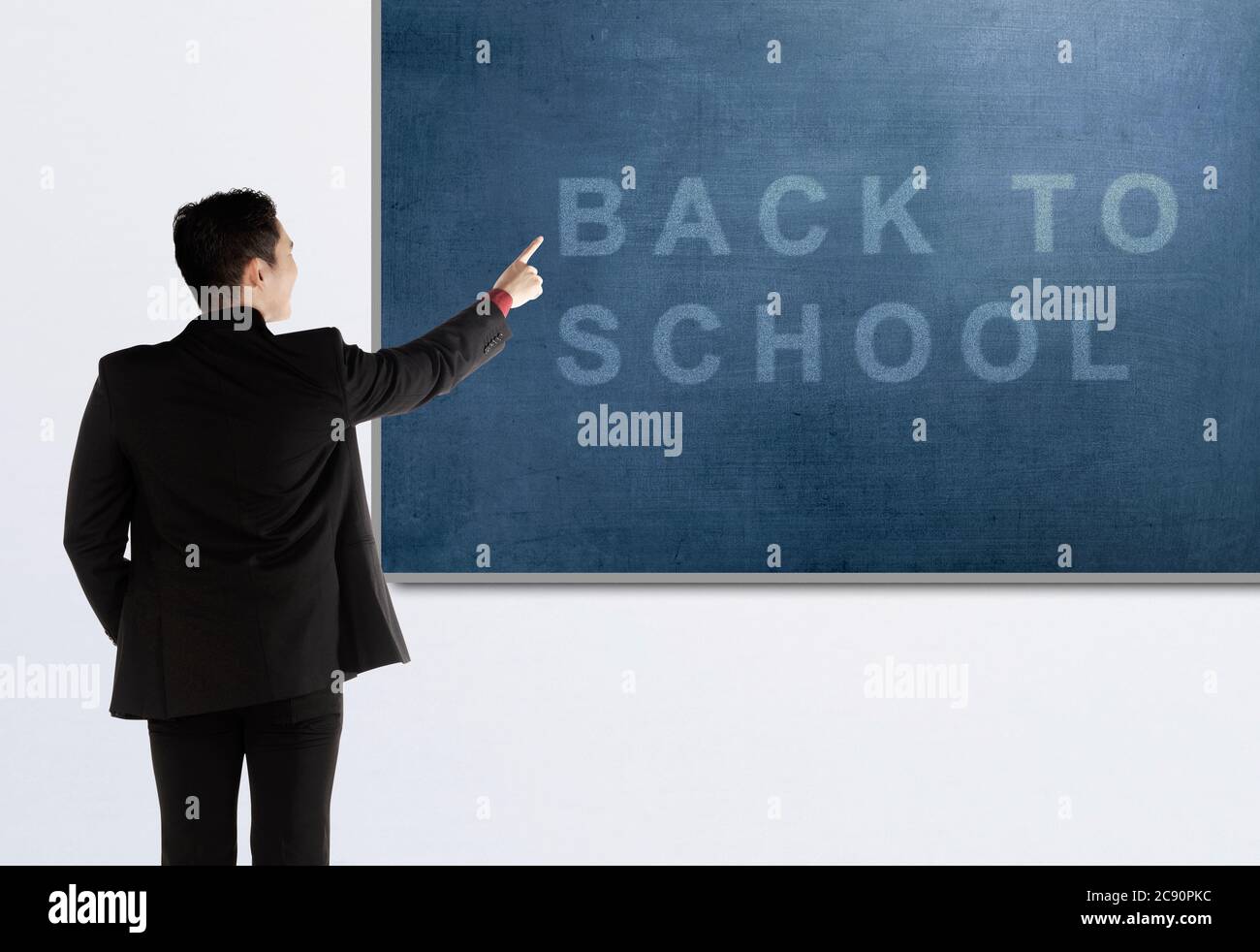 Rear view of Asian teacher man pointing chalkboard with Back to School ...