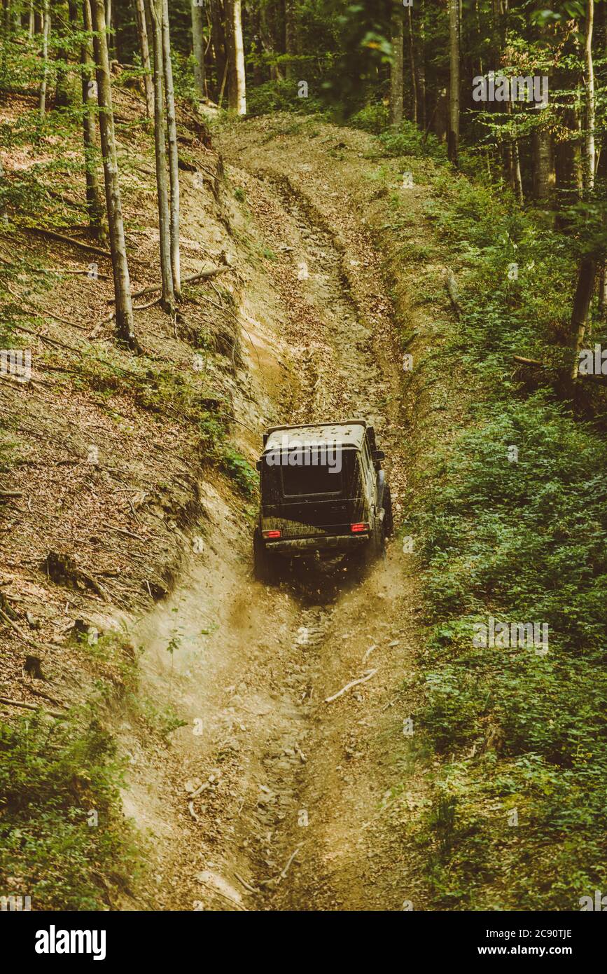 Offroad vehicle coming out of a mud hole hazard. Motion the wheels ...