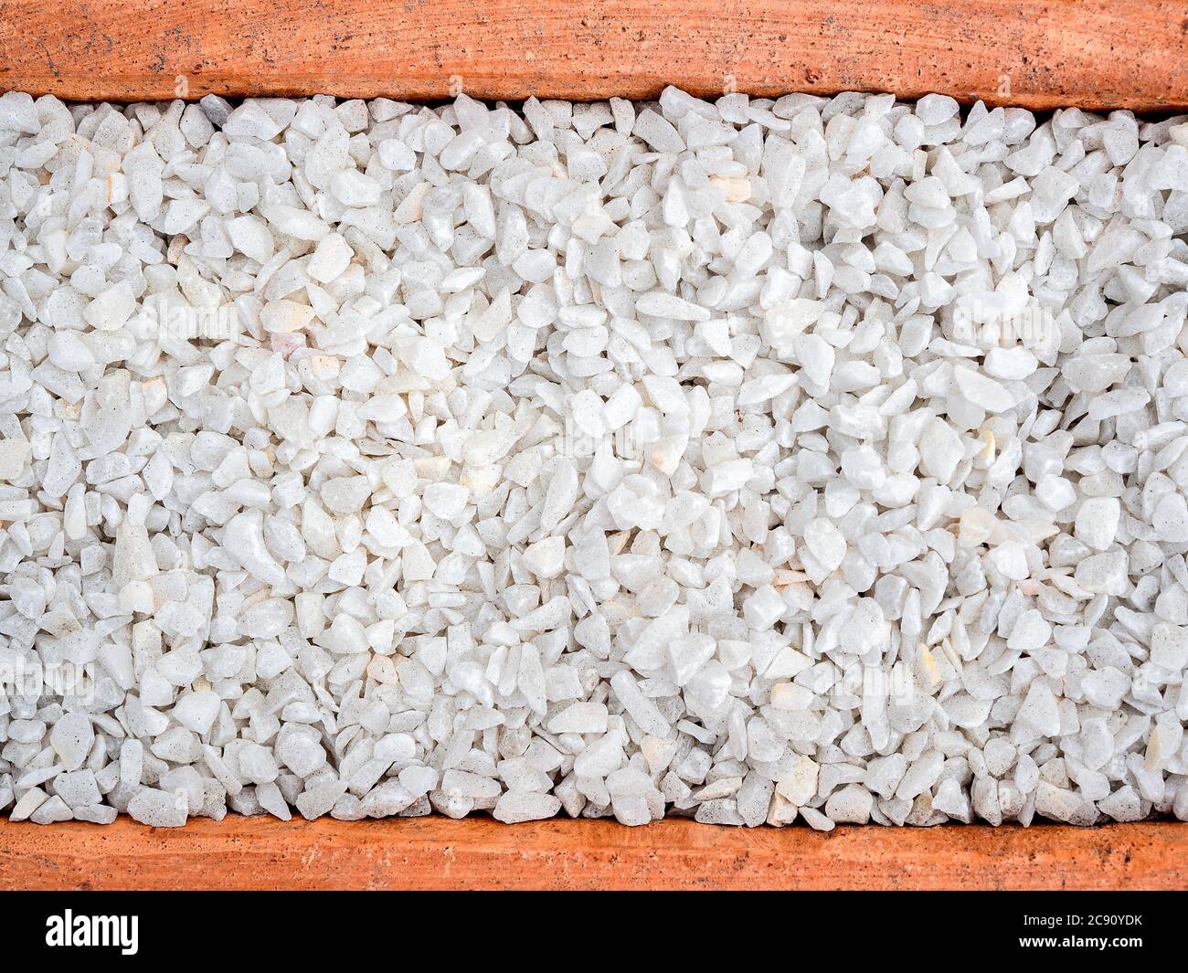 White pebble background. Stone gravel texture in terracotta pot, top ...