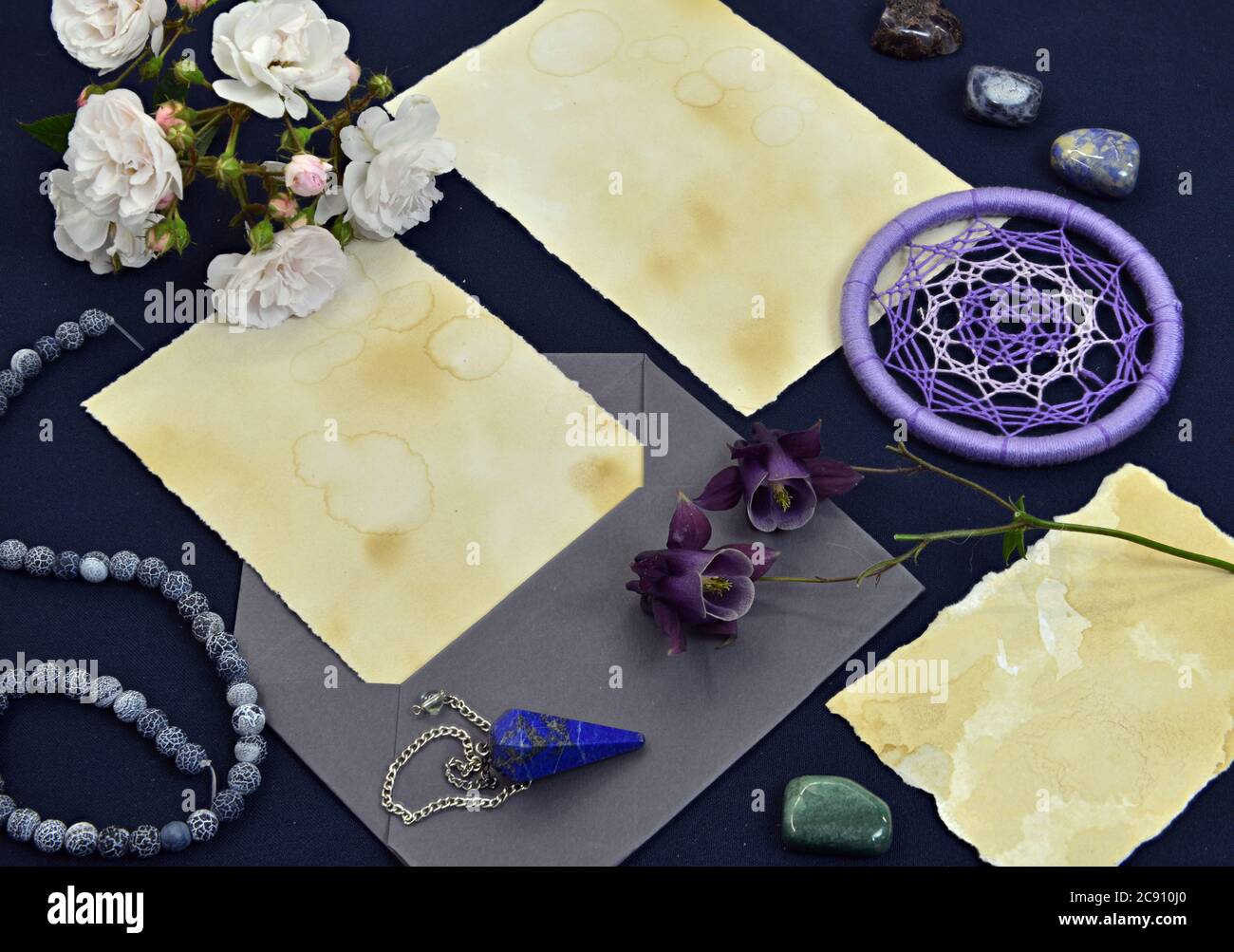 Empty paper sheets with envelope, magic objects, crystal and flower on ...