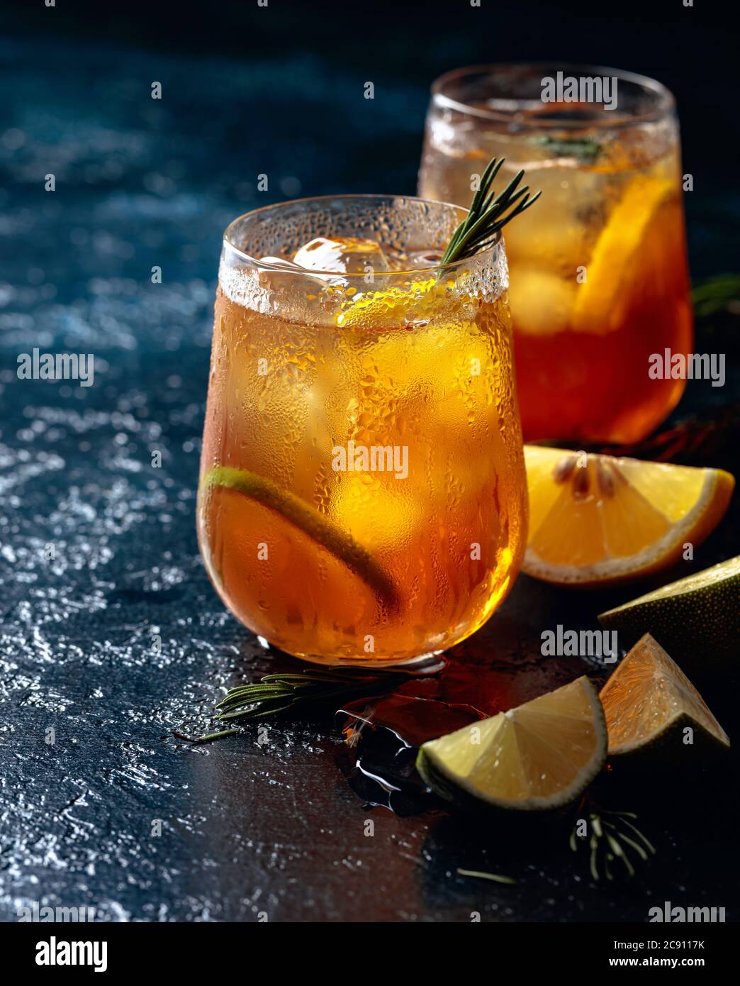 Traditional iced tea with lemon, lime and ice garnished with rosemary ...