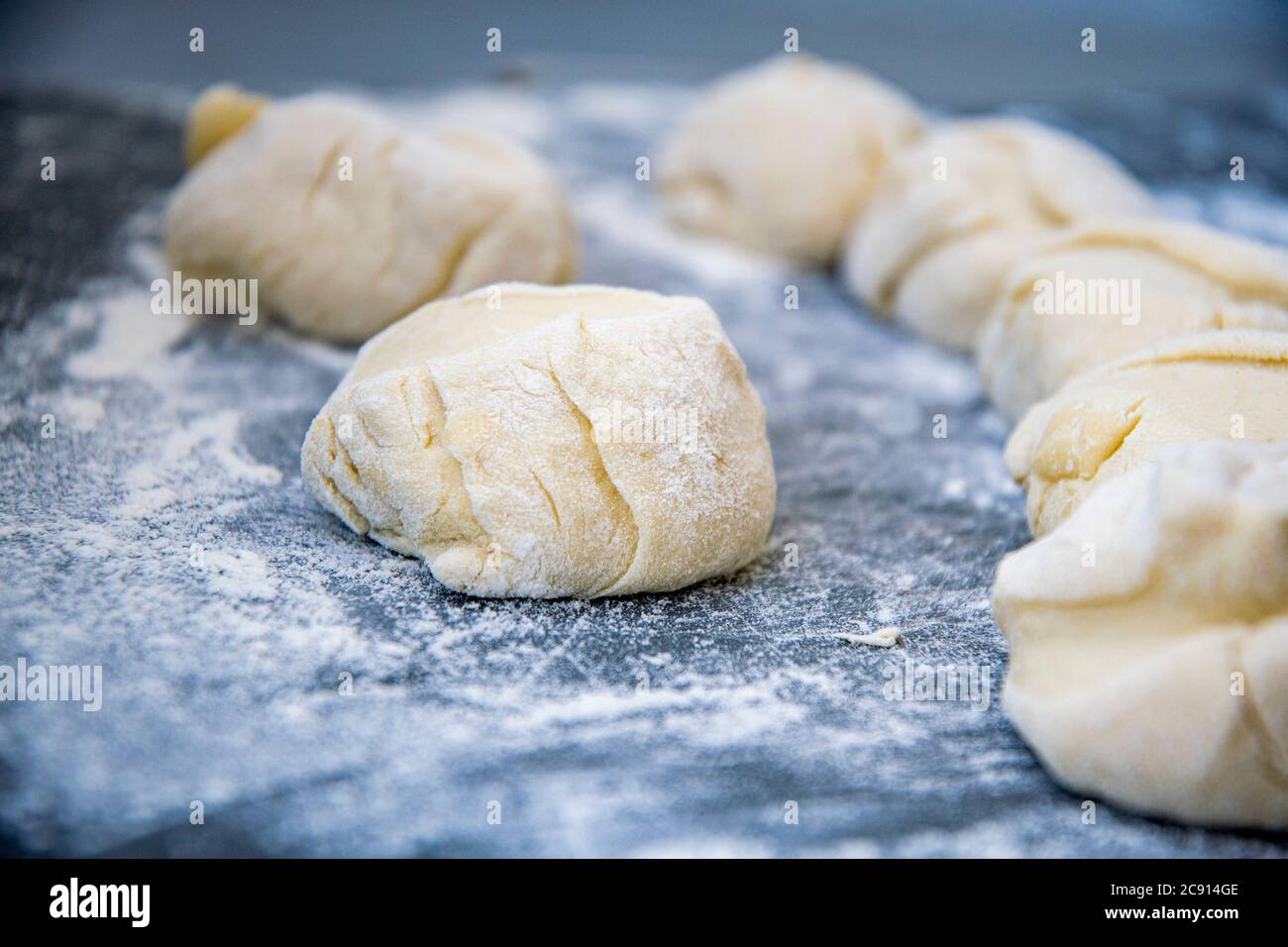 shaped dough pieces on a tray with flour in the kitchen Stock Photo - Alamy