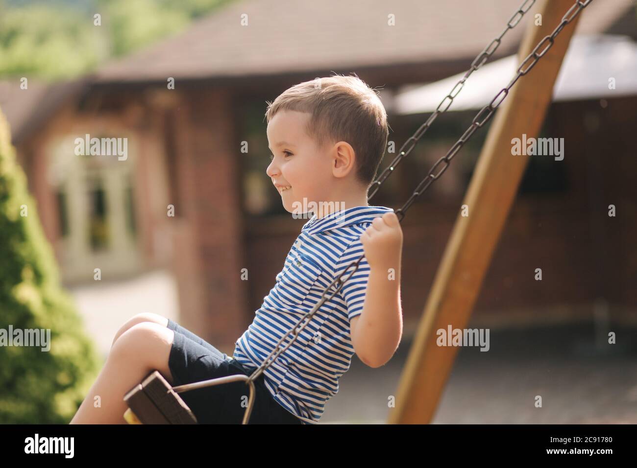 Little boy on the swing. Happy kid outdoors Stock Photo - Alamy