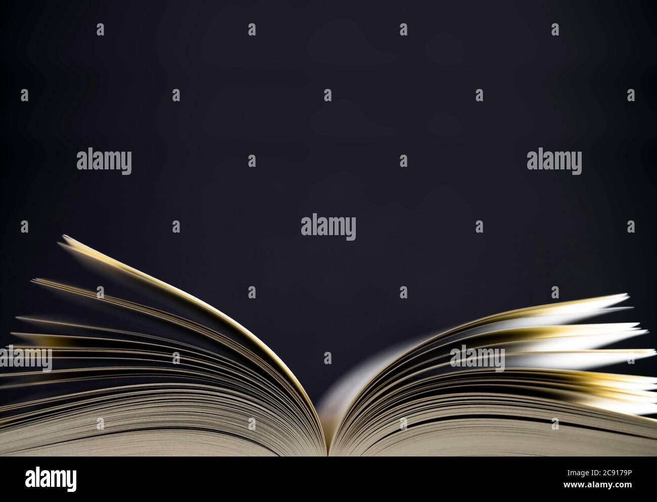 Open book with narrow depth of field on black background. Space for ...