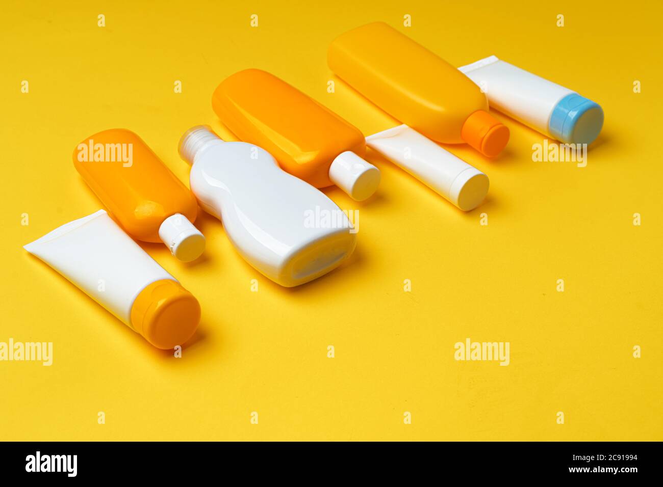 Collection of sunscreen cream bottles on yellow background Stock Photo ...