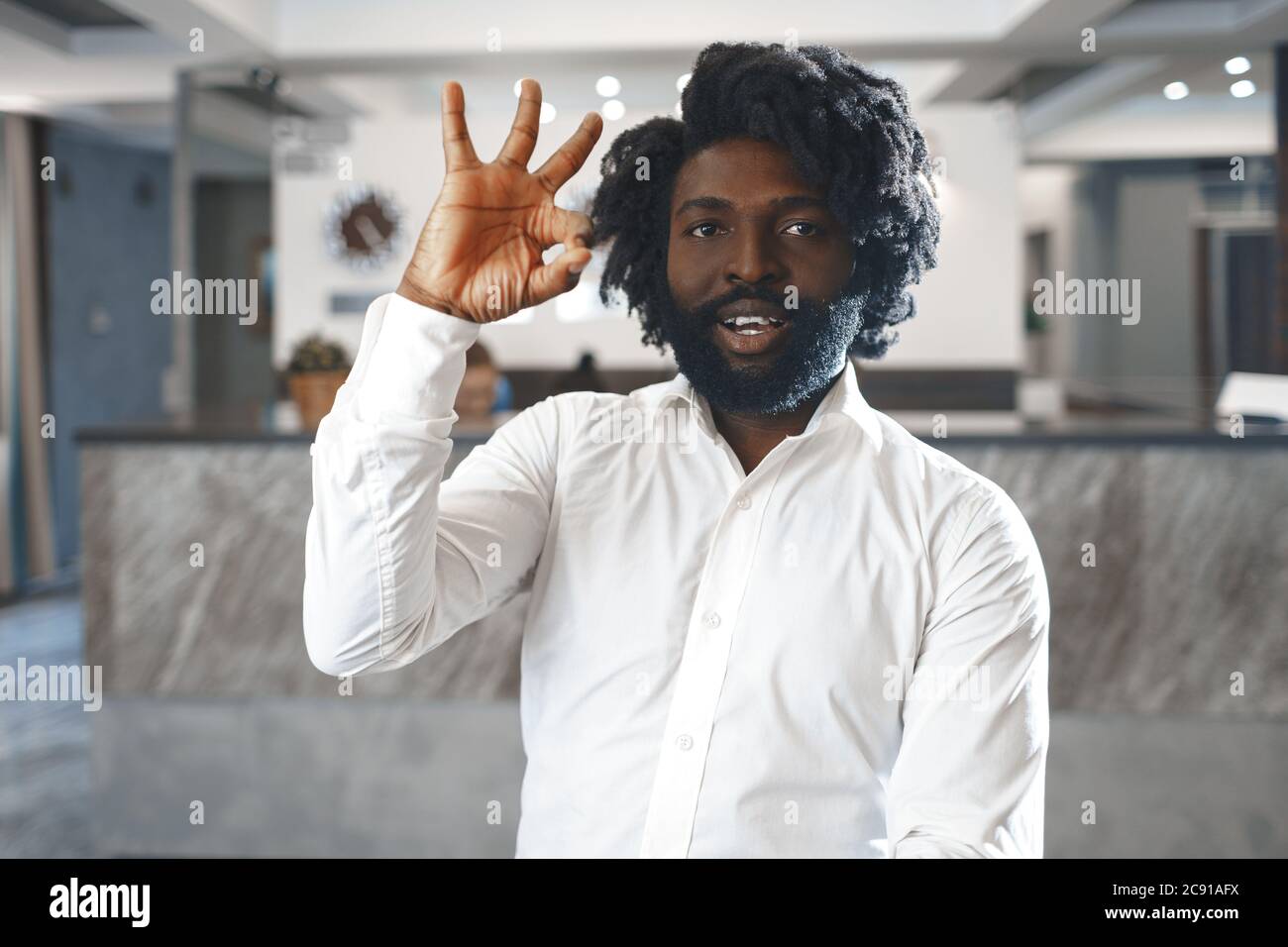 Portrait of a happy african man hotel manager or guest standing against ...