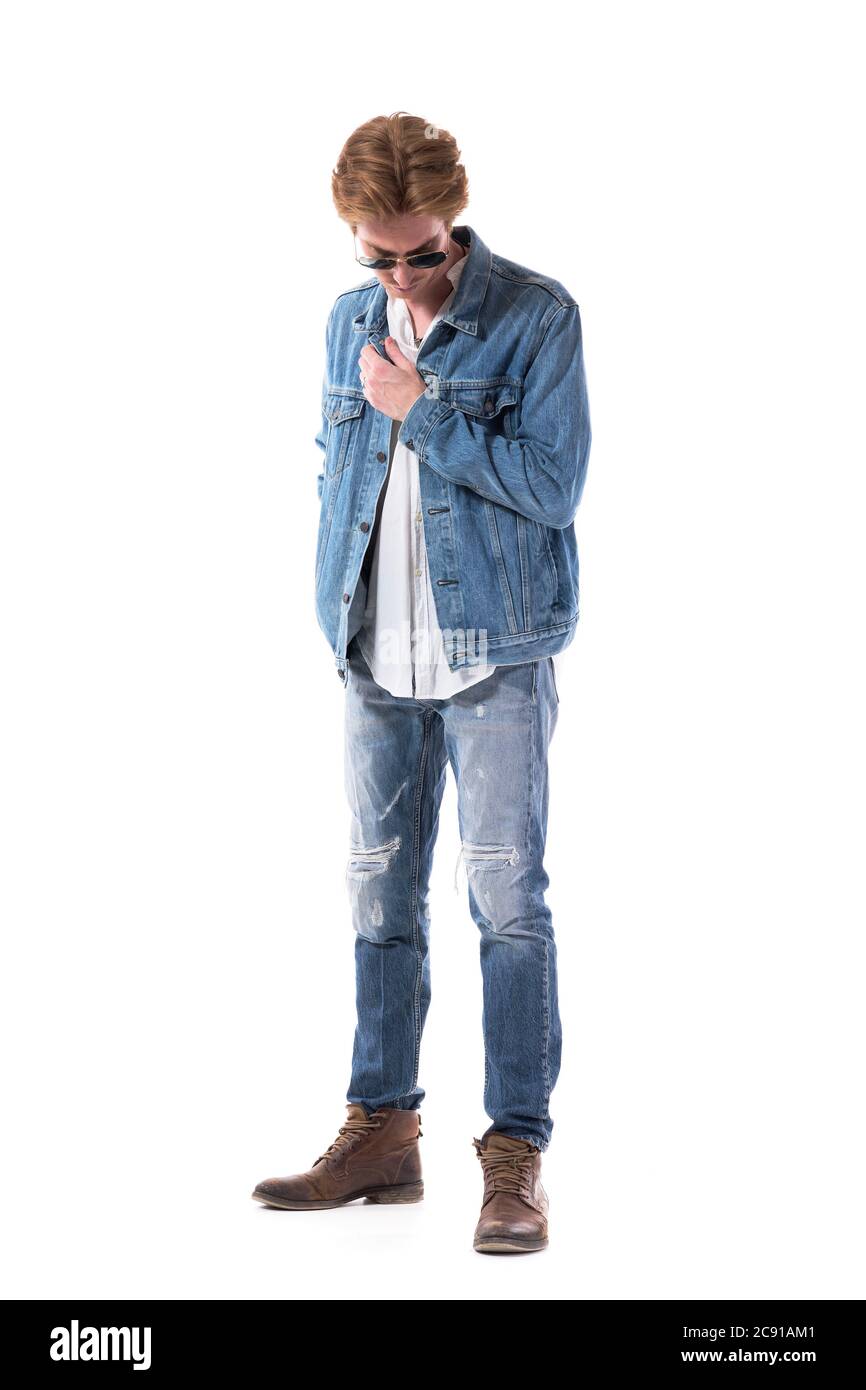 Stylish handsome man in jeans looking down on ground searching for ...