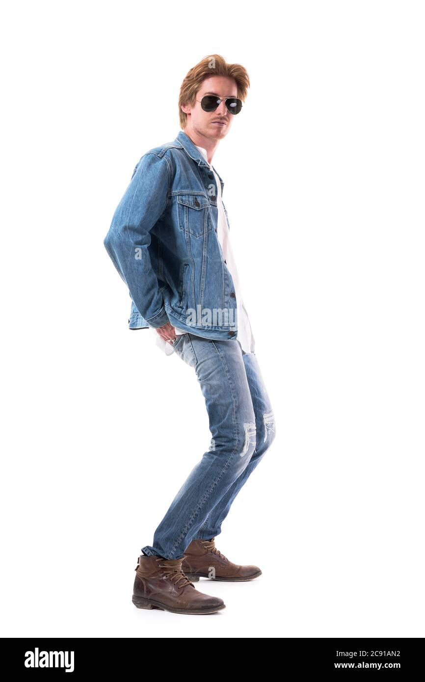 Handsome young red hair male fashion model in jeans posing and bending ...