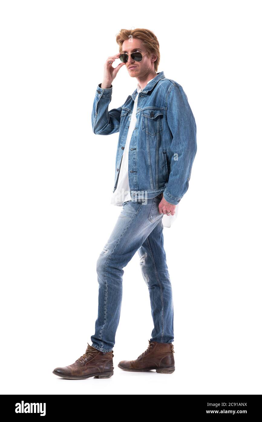 Side view of handsome stylish man in jeans clothes holding and looking ...