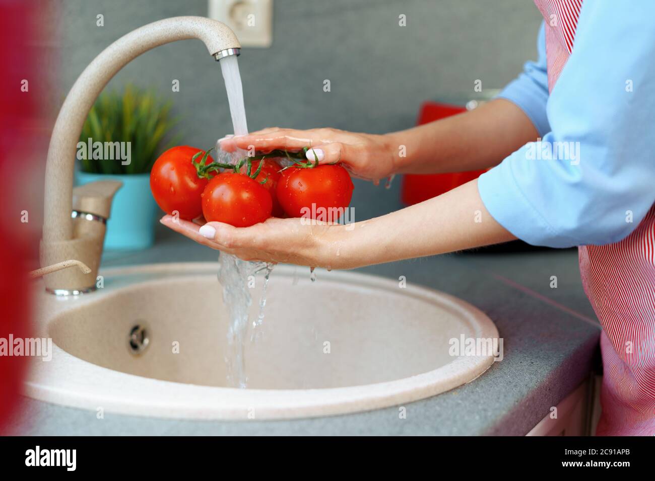 Close up photo of woman washing tomatoes in a sink Stock Photo - Alamy