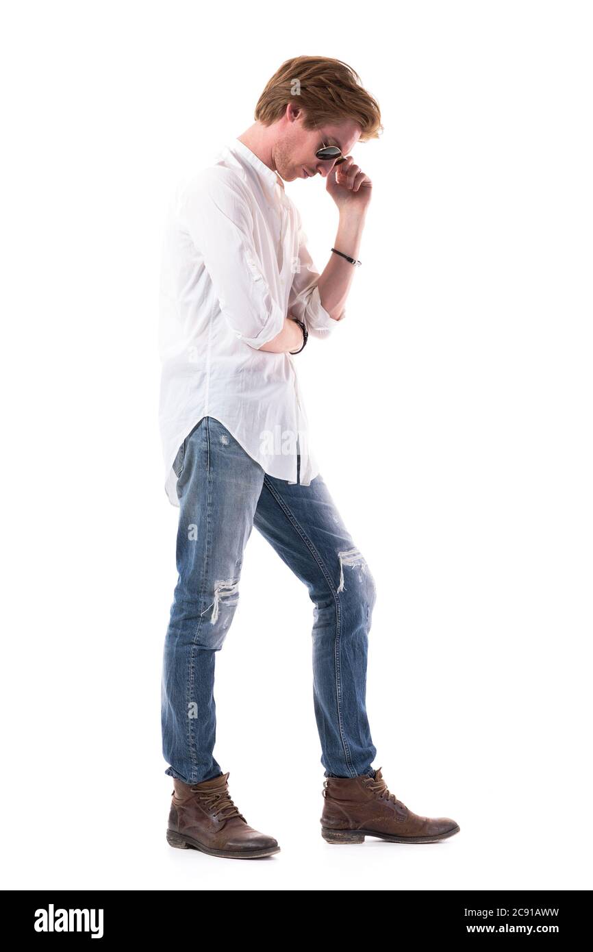 Sad concerned young handsome man looking down thoughtful. Side view ...