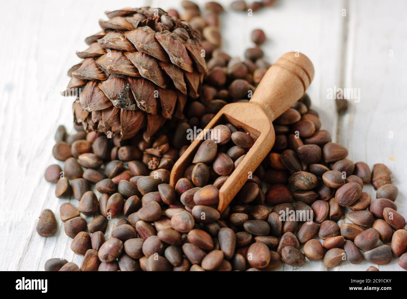 Cedar nuts in wooden scoop over heap of cedar nuts Stock Photo - Alamy